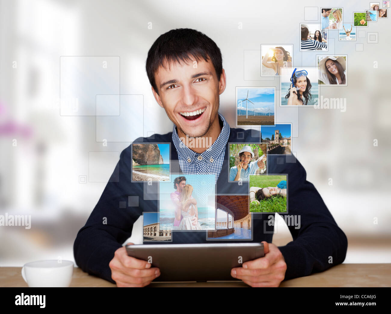 A technology man has images flying away from his modern tablet computer ...