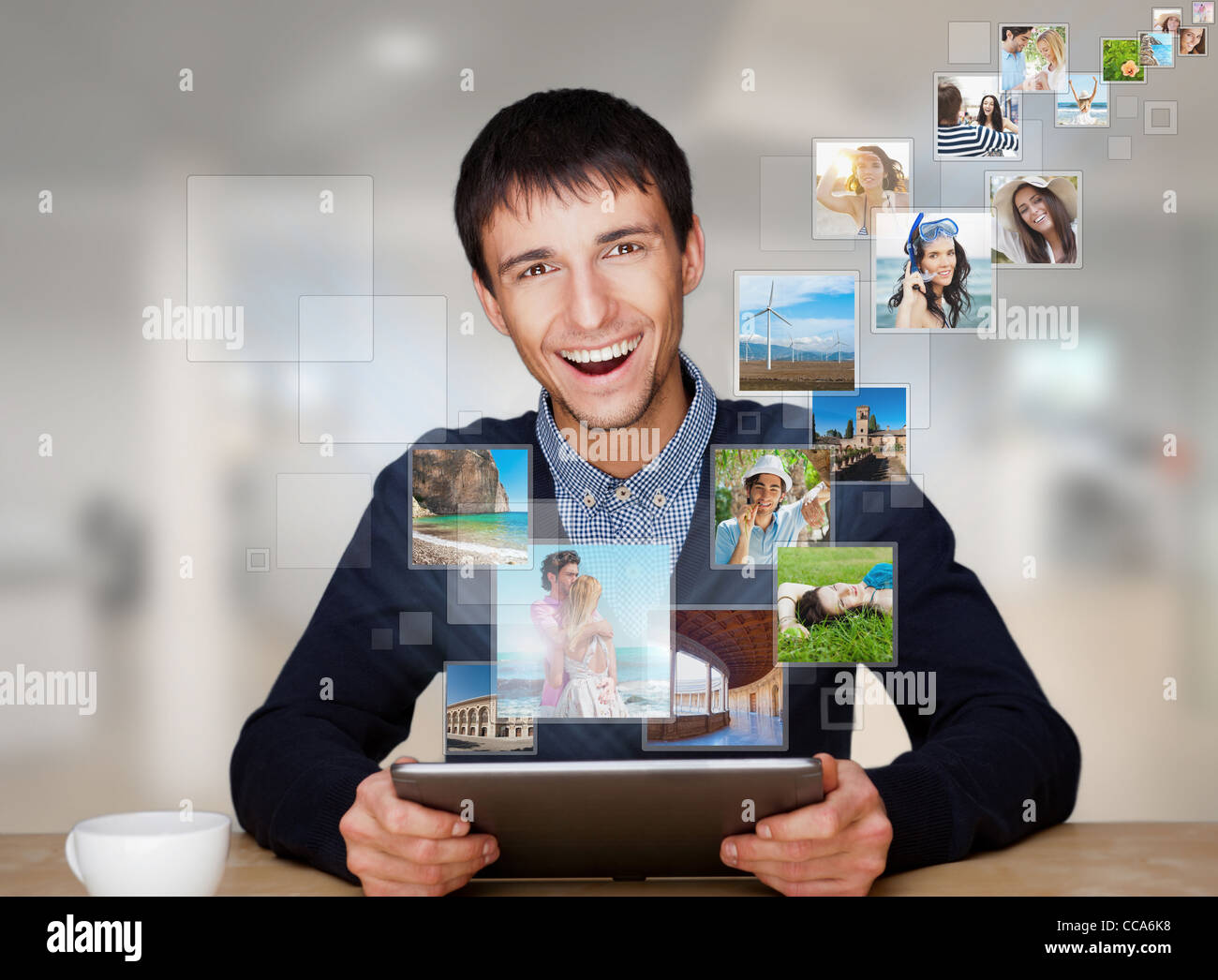 A technology man has images flying away from his modern tablet computer ...