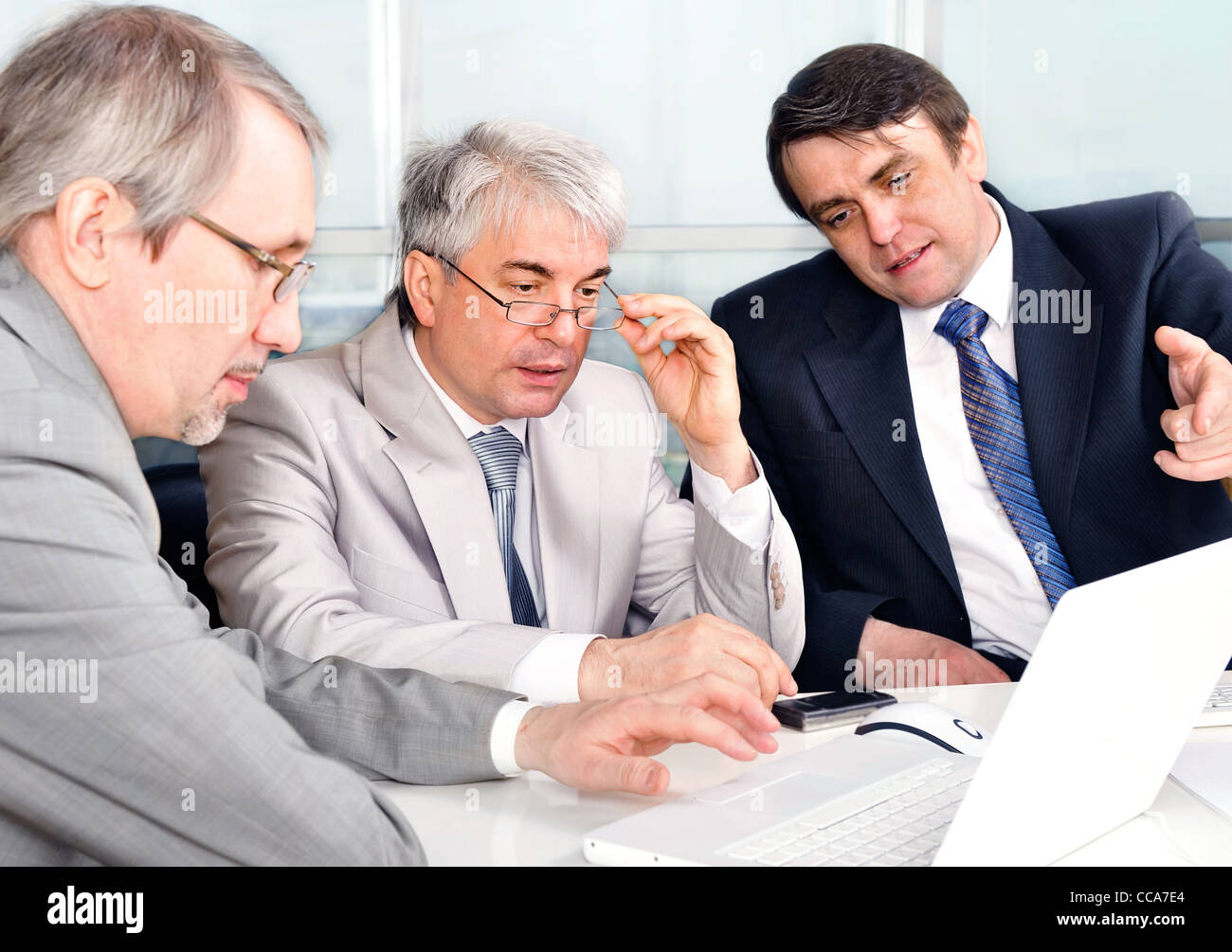 Portrait of three businessmen at the computer. Office background Stock ...