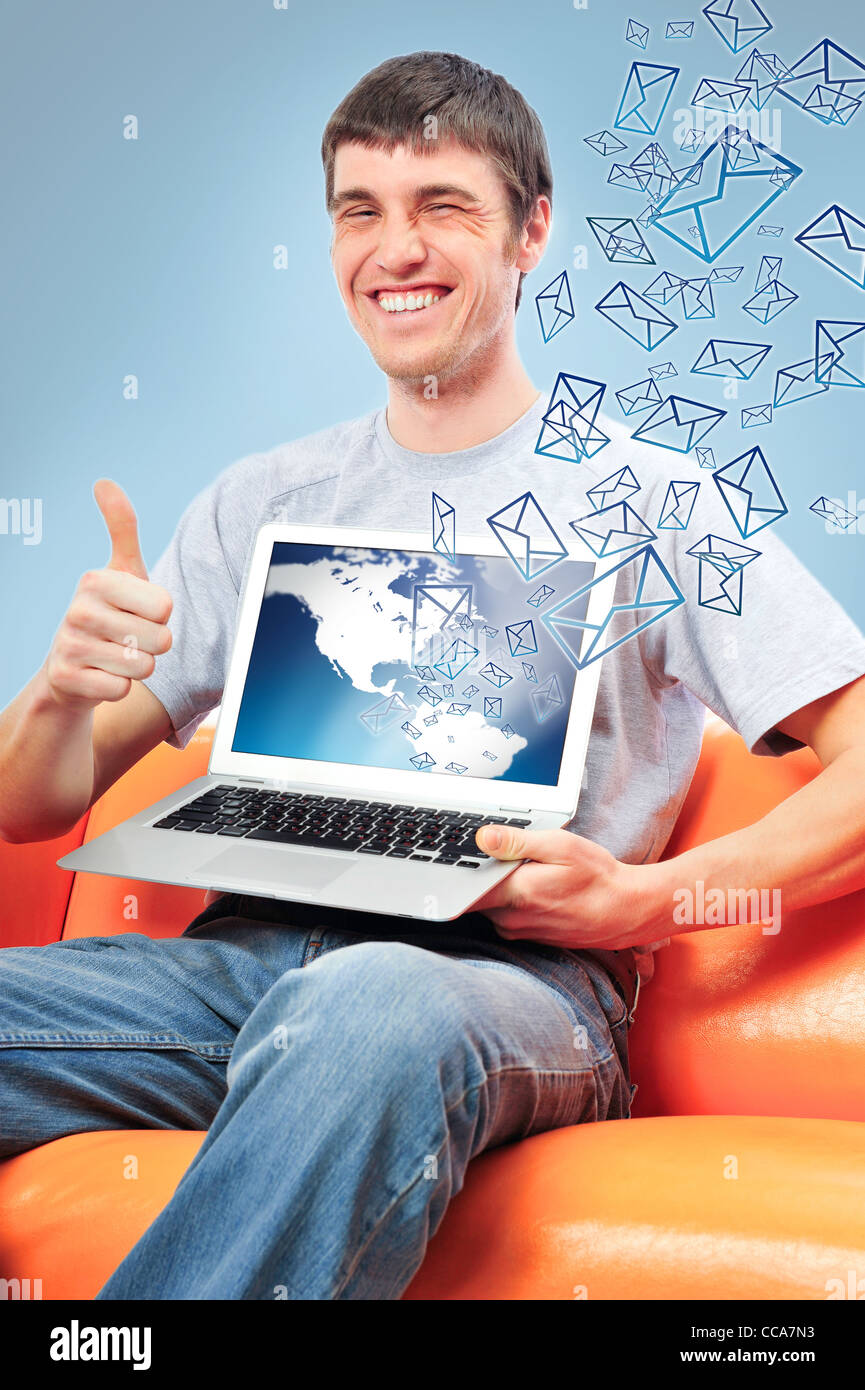 Portrait of handsome young man holding laptop computer and working with ...