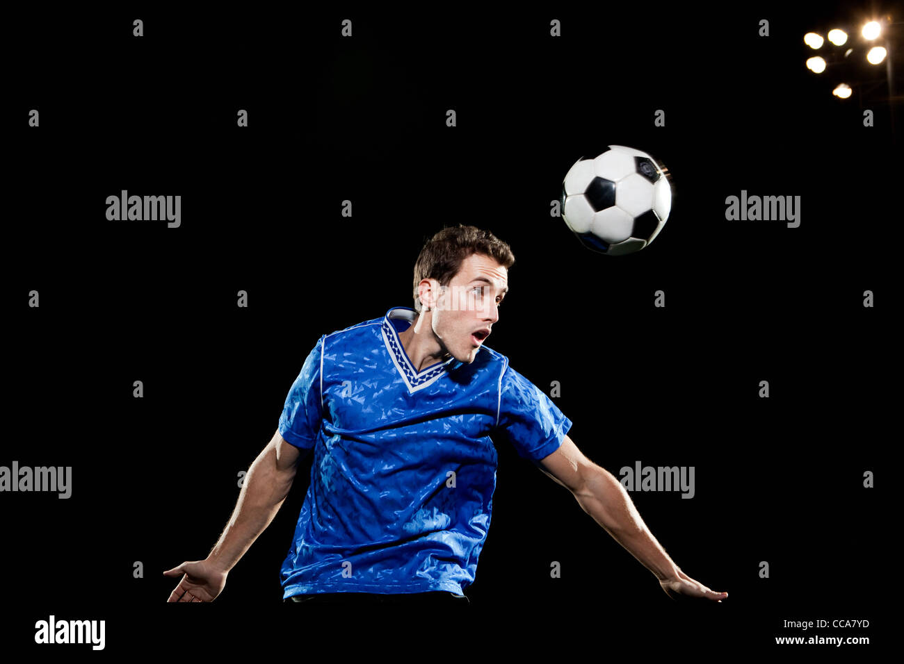 Young man leaping to head soccer ball Stock Photo - Alamy