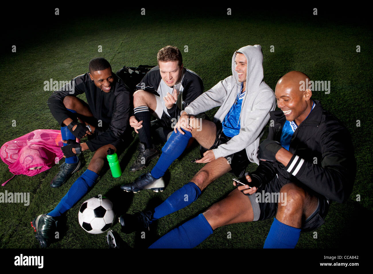 Soccer team resting on pitch after game Stock Photo - Alamy