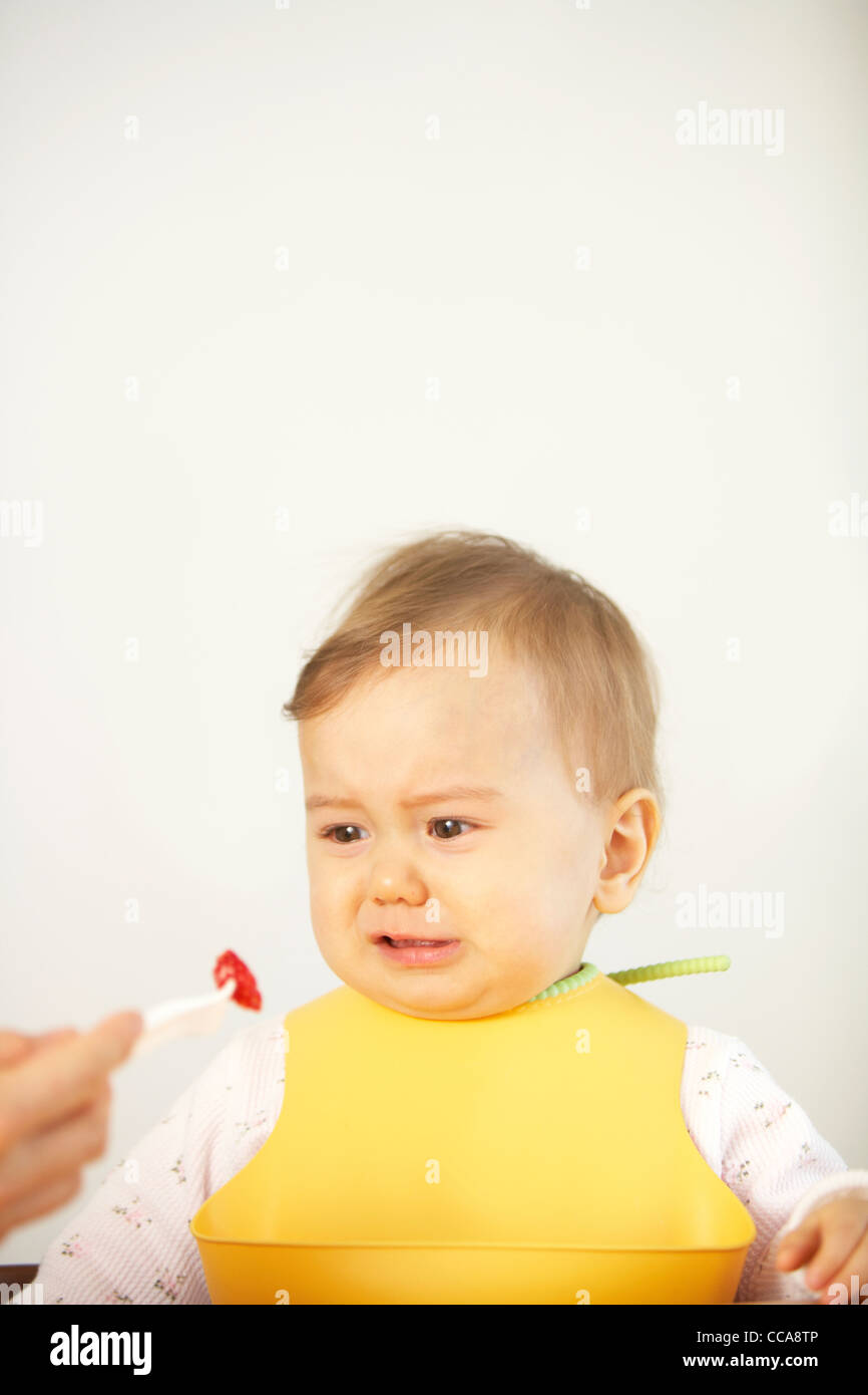 Unhappy Baby Girl Being Fed Stock Photo - Alamy