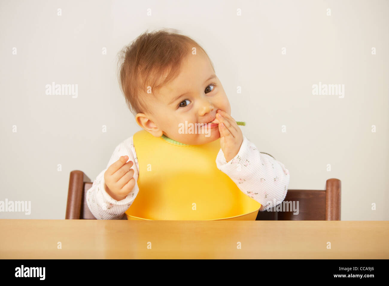 Baby Girl Eating with Hand Stock Photo - Alamy