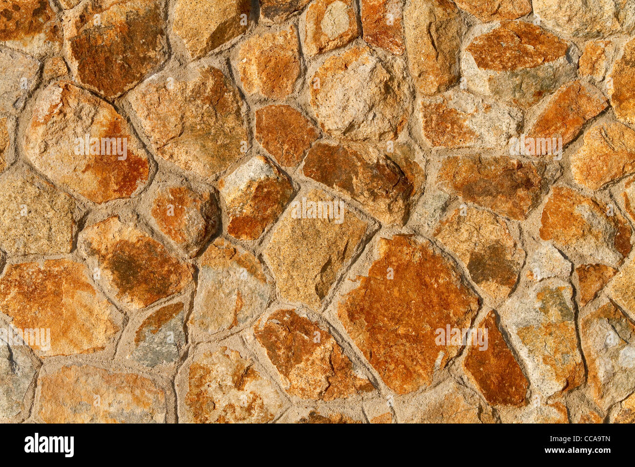 Close up of an orange tinted stone wall background Stock Photo - Alamy