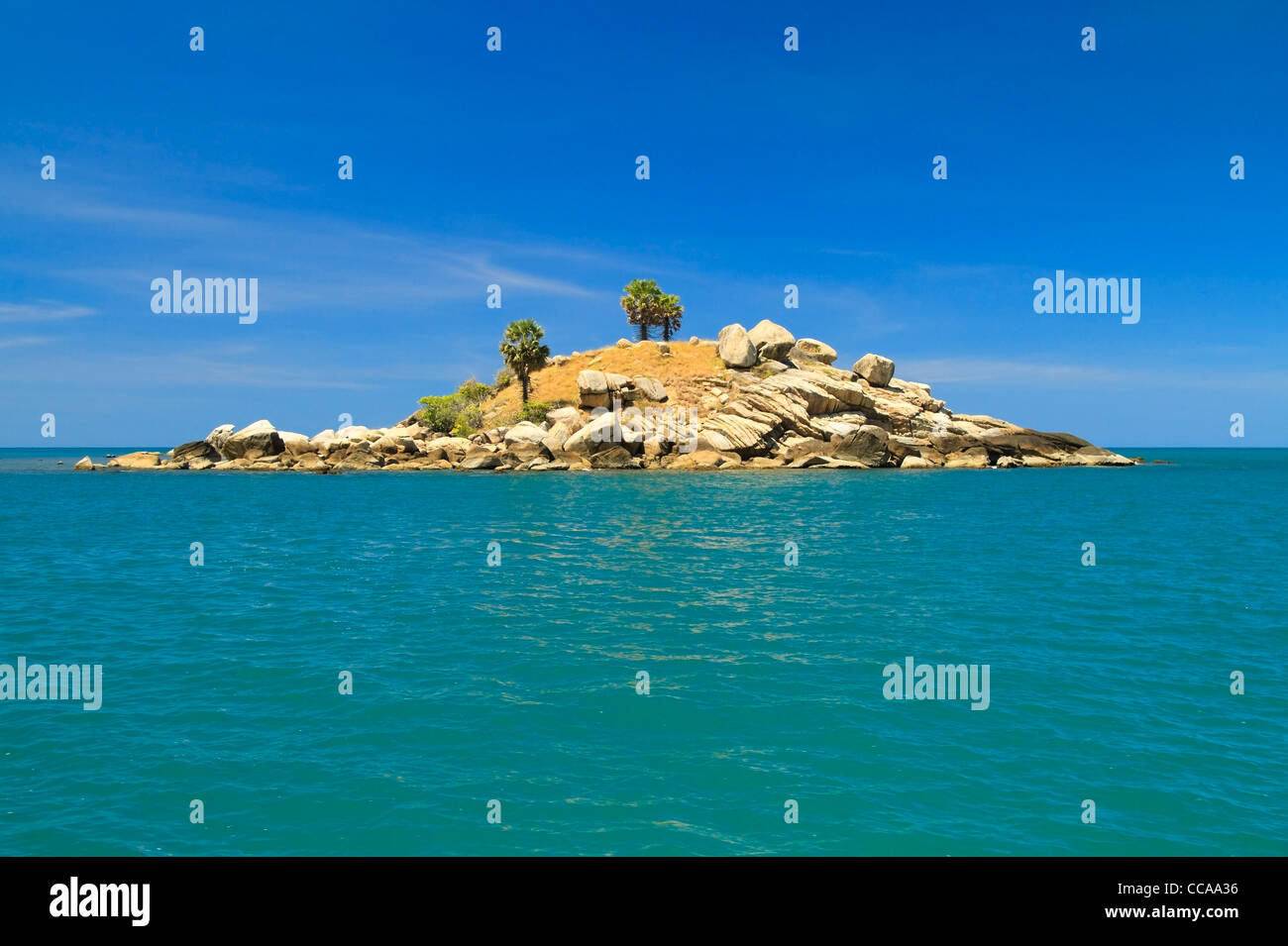 Dry uninhabited island off the coast of Thailand with a blue sky and ...