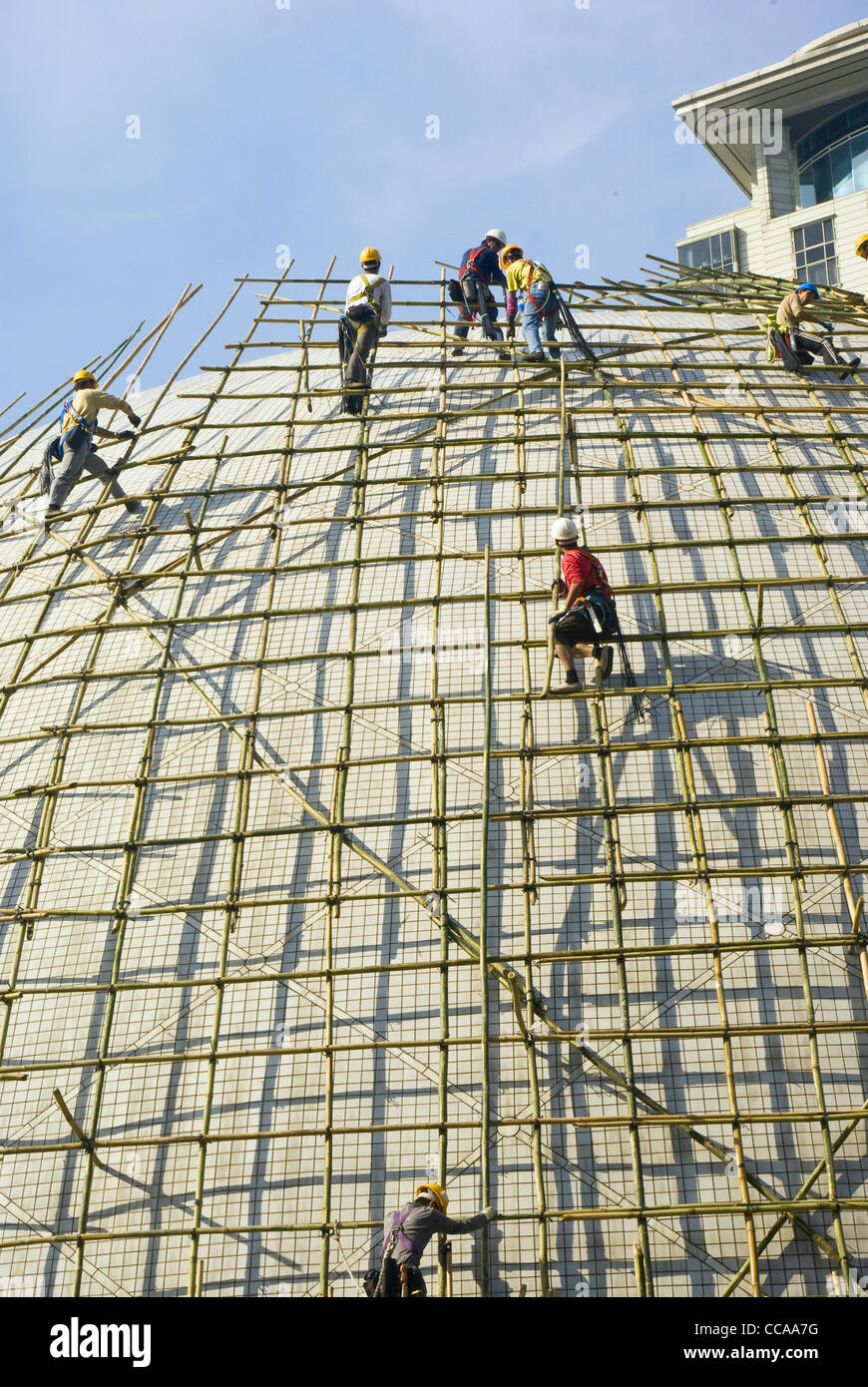 Closeup of construction worker assembling scaffold on building site ...