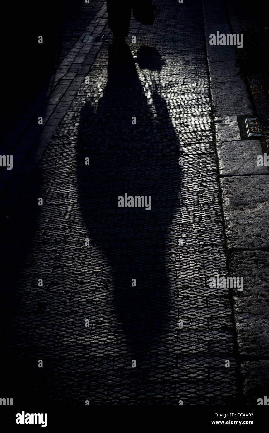 Shadow of shopper in Cobbled streets of Dartmouth,Brick paved street ...