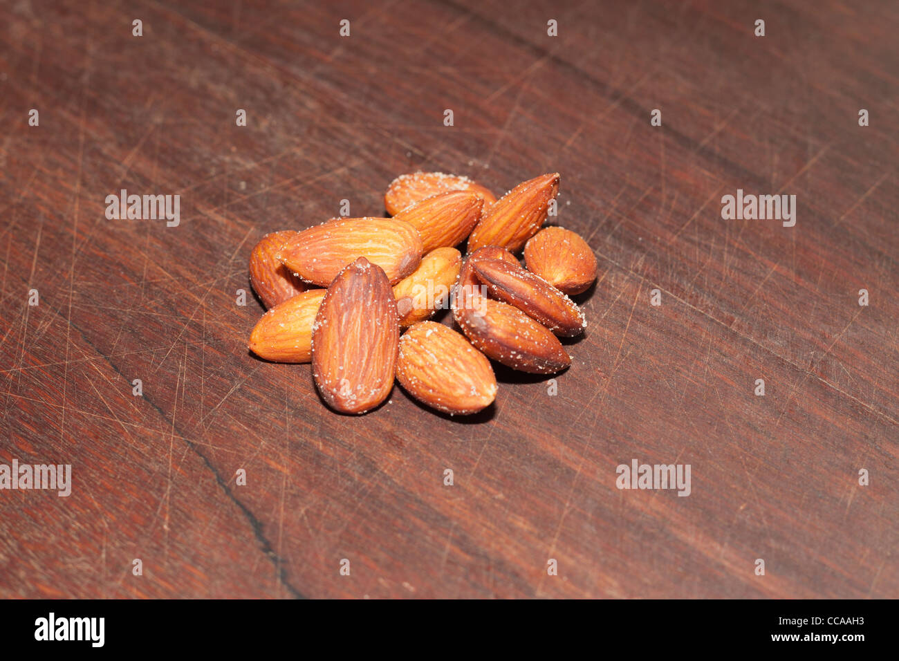 Salted whole almonds on a wooden board Stock Photo - Alamy
