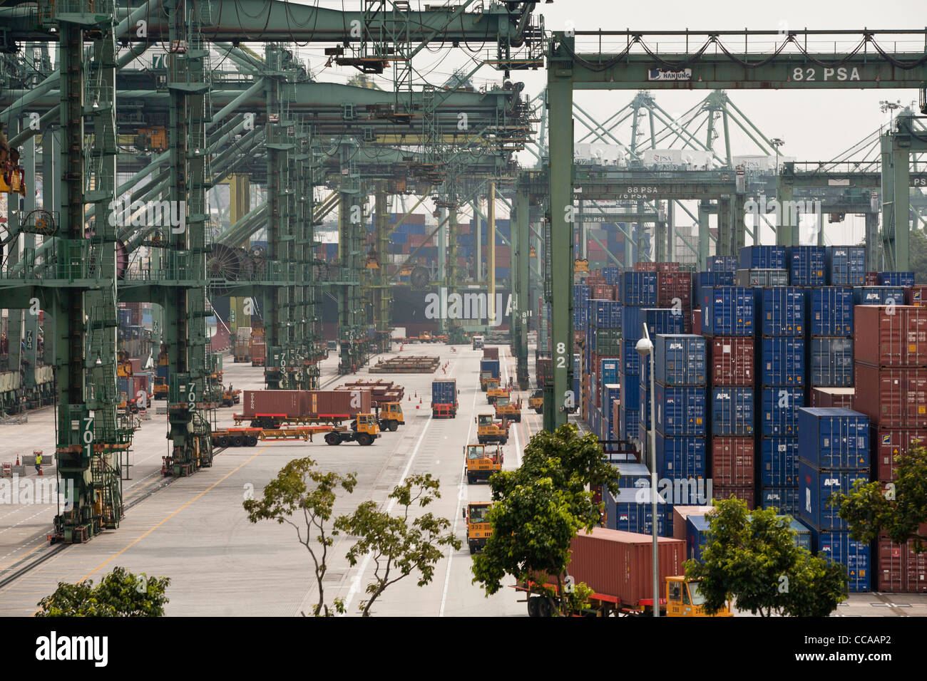 Trucks transport containers at the quayside of the Brani Terminal at ...