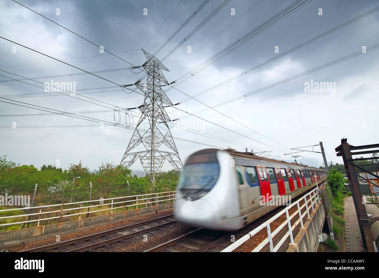 speed train under the power tower Stock Photo - Alamy