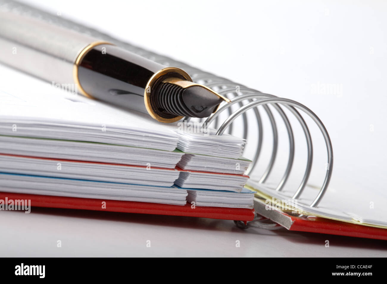 fountain pen lays on a writing-book with spiral Stock Photo - Alamy