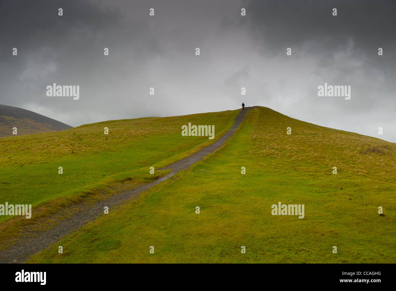 A lone walker crosses the summit of Latrigg Stock Photo - Alamy