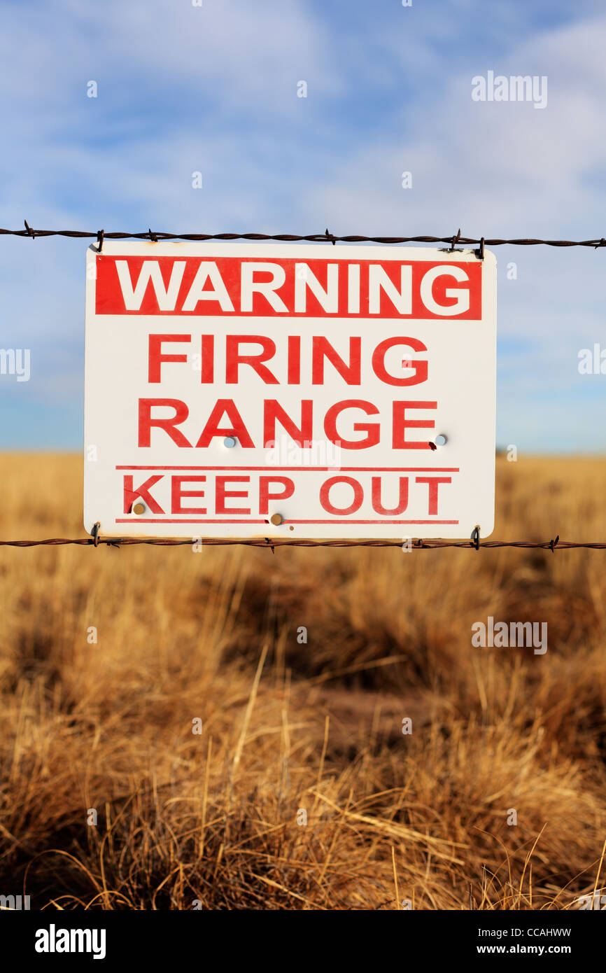 Warning Firing Range Keep Out sign hanging on a barbed wire fence Stock ...