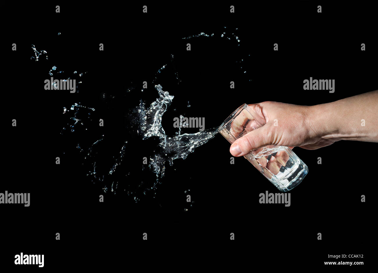 man throws water from a glass on a black background Stock Photo - Alamy