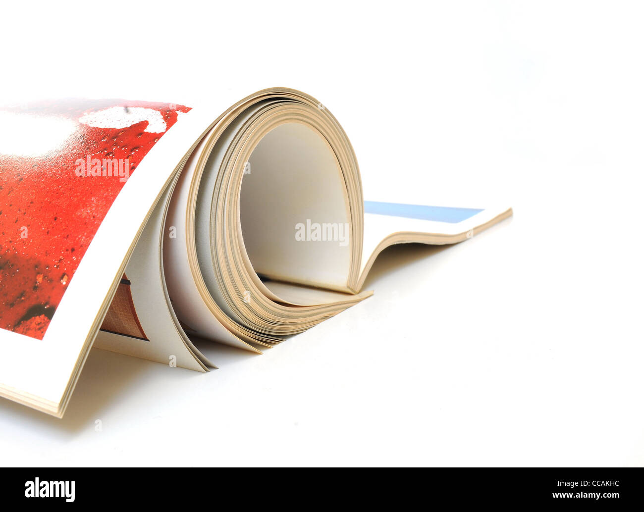 Rolled up magazine on white background Stock Photo - Alamy