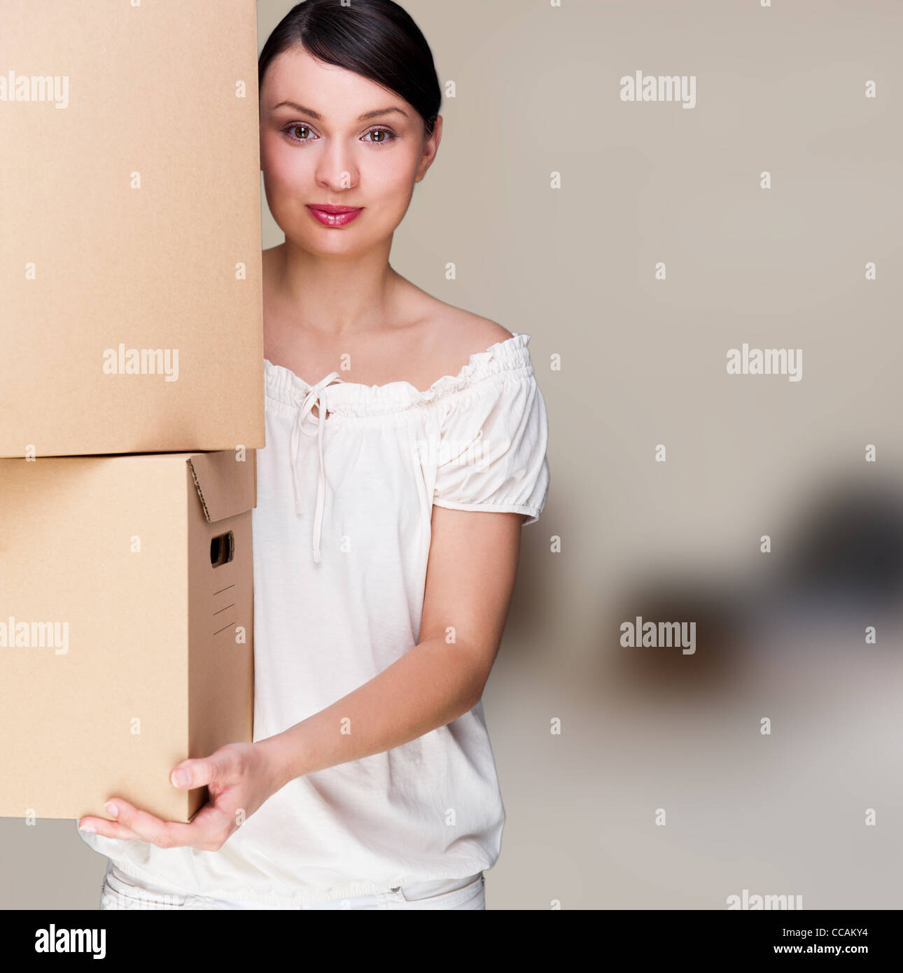 Smiling woman holding boxes after moving looking at the camera Stock ...