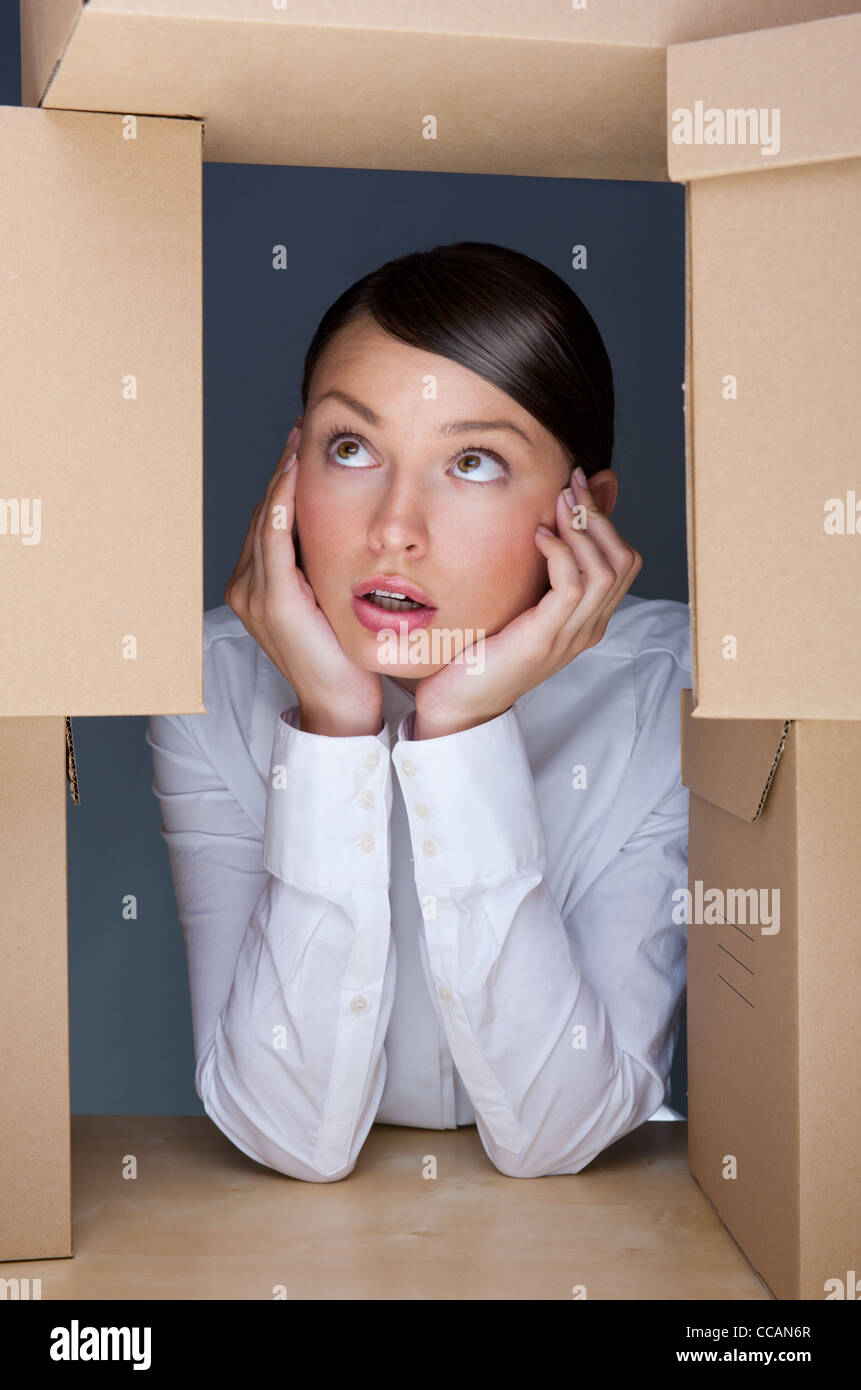 Portrait of young woman surrounded by lots of boxes. Lots of work ...