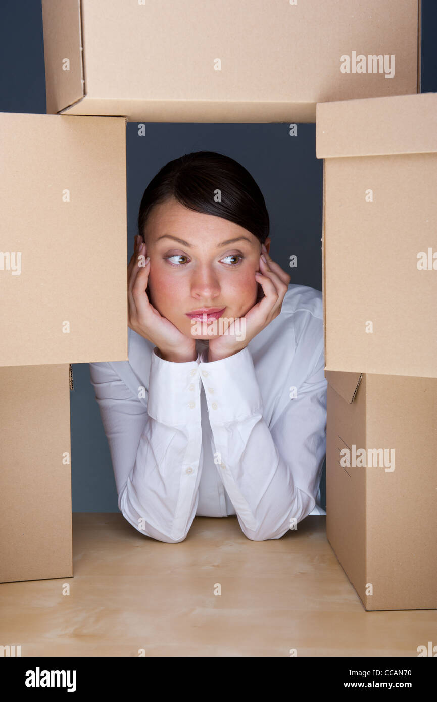 Portrait of young woman surrounded by lots of boxes. Lots of work ...