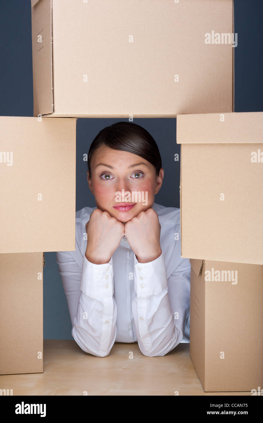 Portrait of young woman surrounded by lots of boxes. Lots of work ...