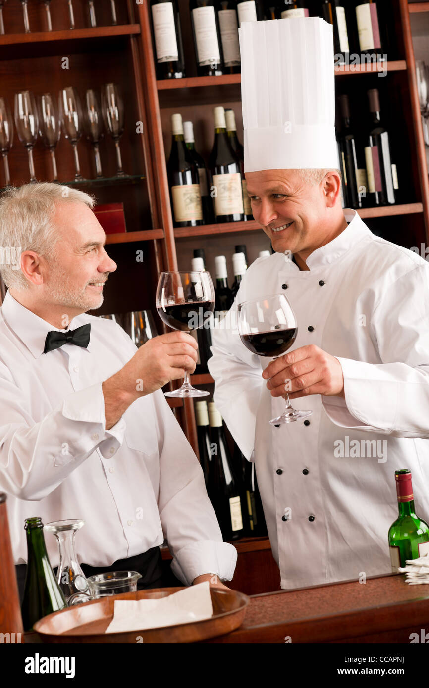 Chef cook and waiter toasting with wine smiling in restaurant Stock ...