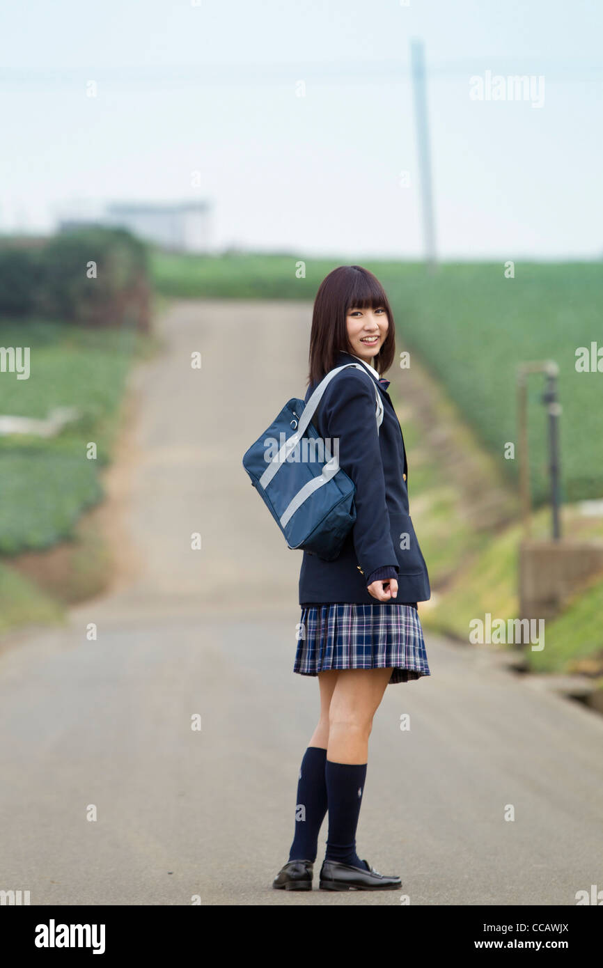 Female High School Student Standing on Rural Road Stock Photo - Alamy