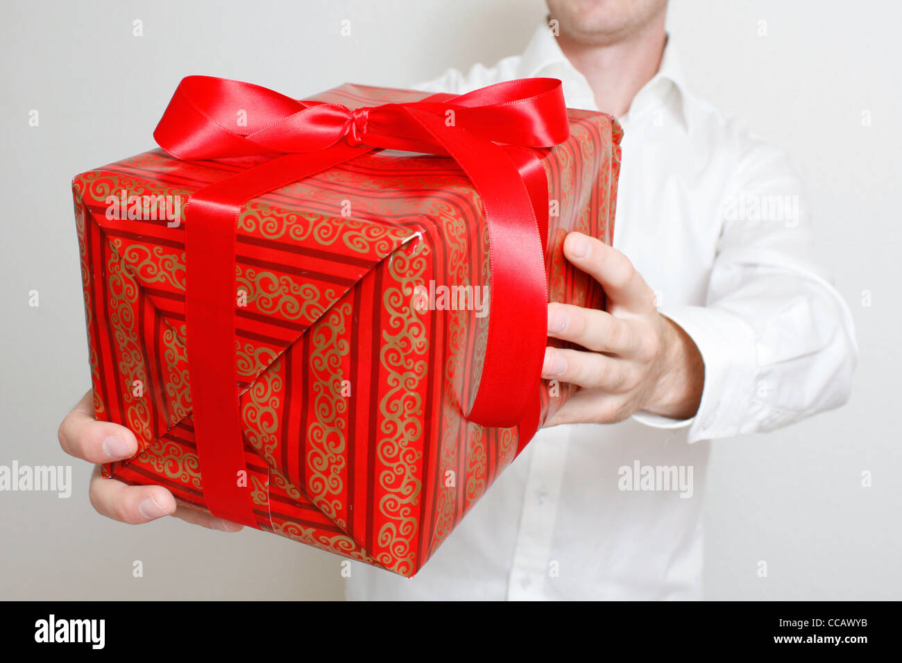 A man presenting a christmas present Stock Photo - Alamy