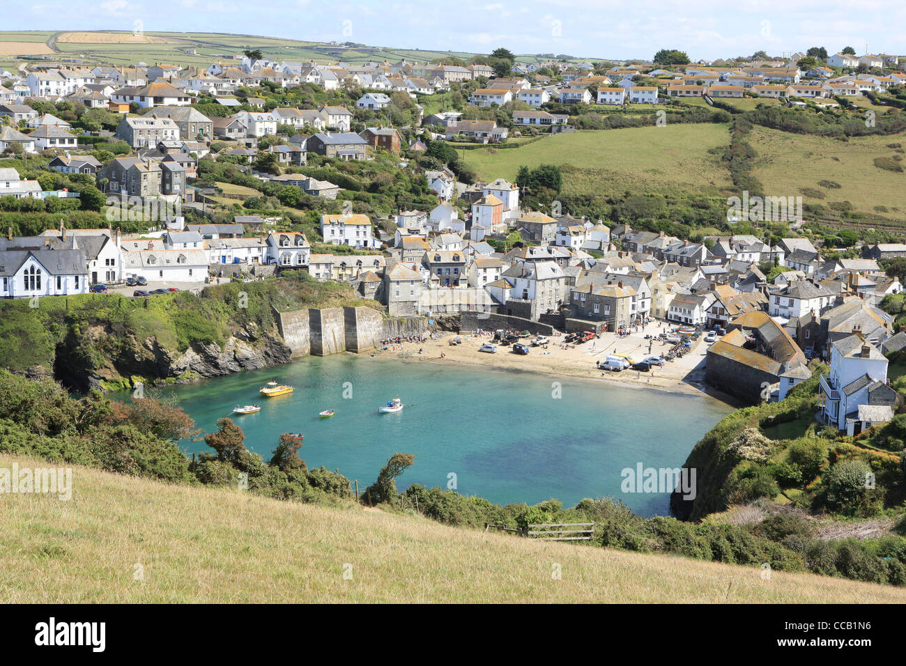 A couple on a seat looking over the harbour at Port Isaac on the North ...