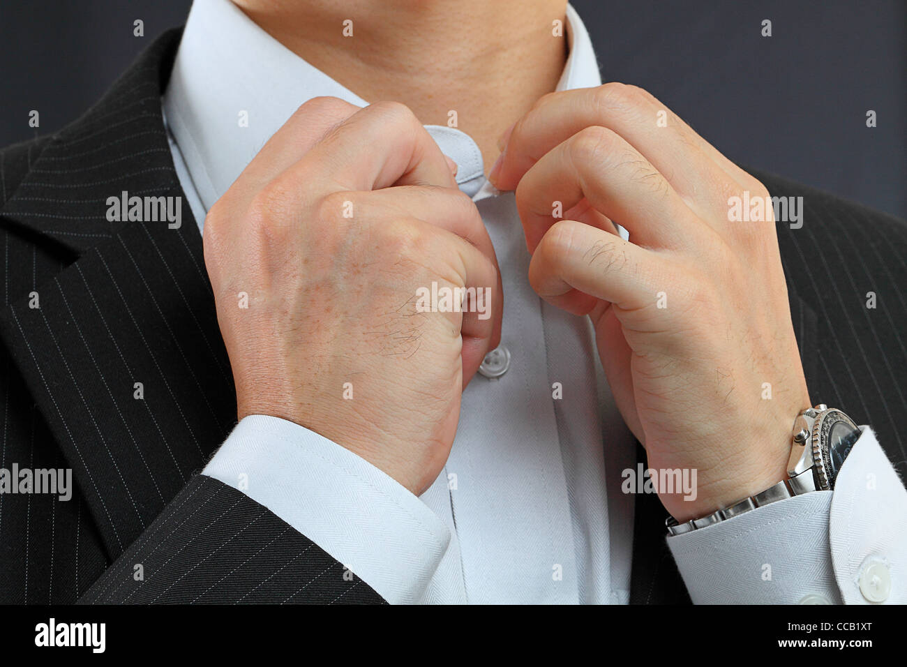 young man adjusting his suit on a black background Stock Photo - Alamy