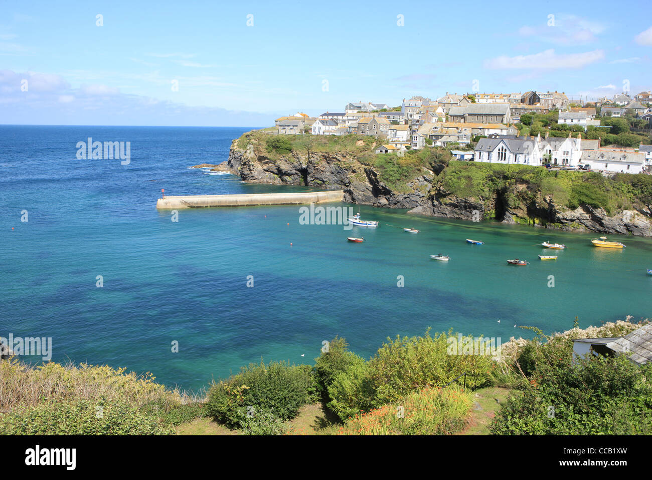 A couple on a seat looking over the harbour at Port Isaac on the North ...