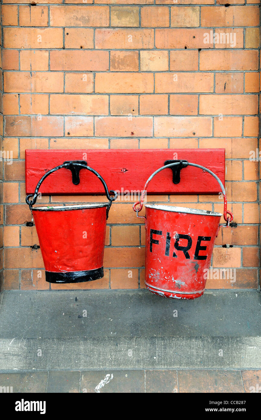 red fire buckets attached to a railway station wall england uk Stock ...