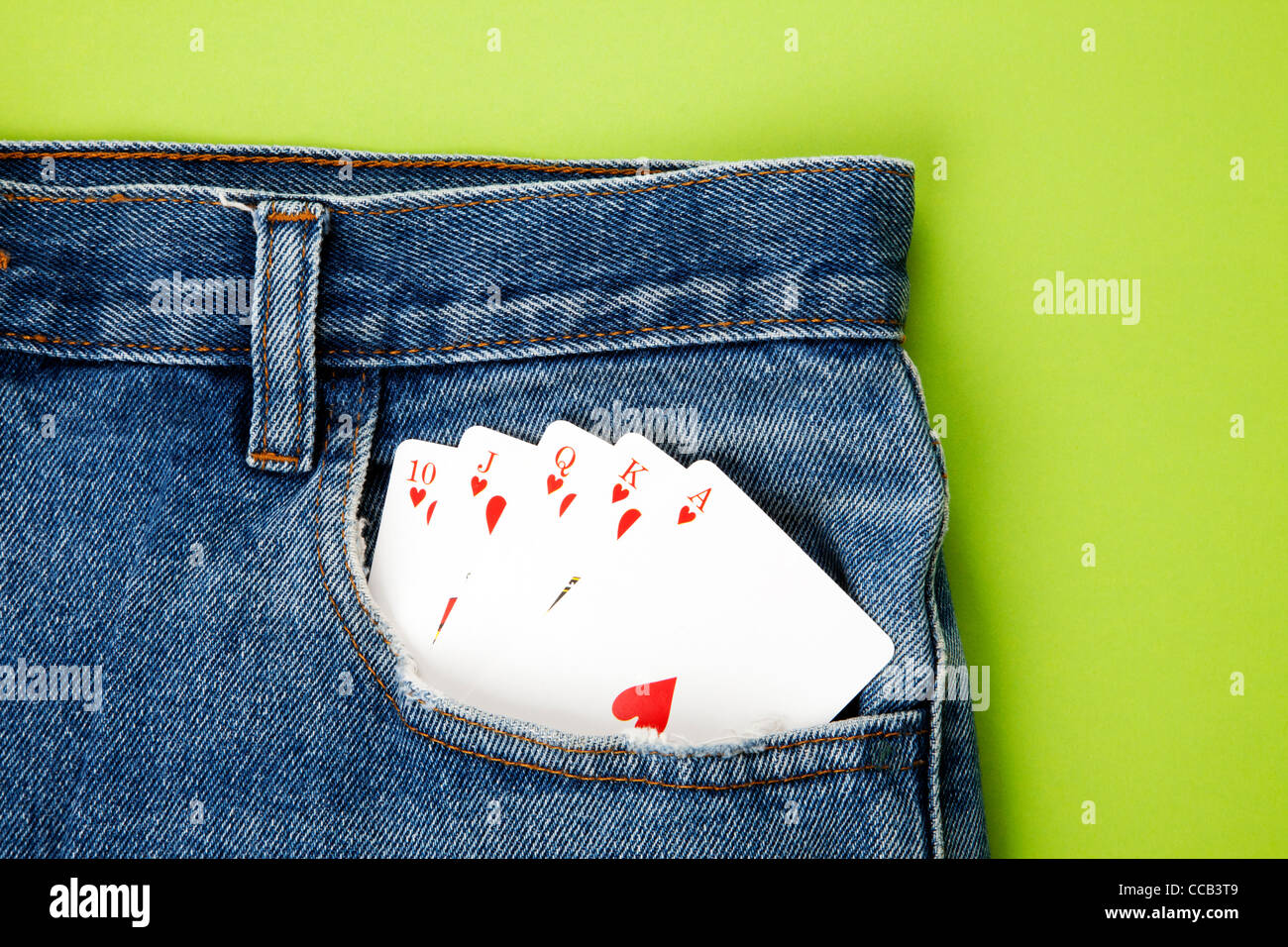 Royal flush with playing cards in blue jeans pocket with green ...