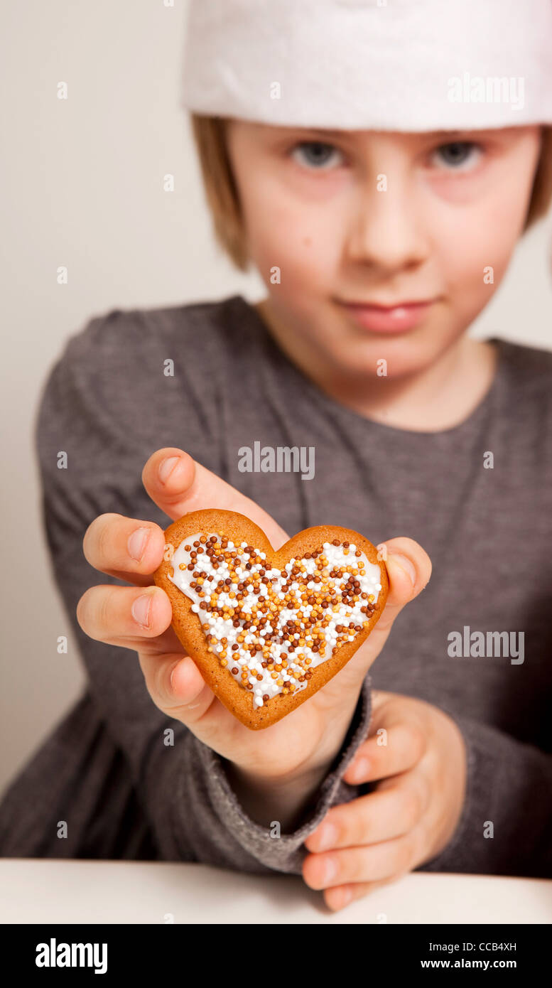 Girl holding a heart shaped decorated Christmas gingerbread Stock Photo ...