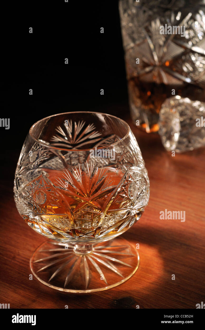 crystal brandy glass on the oak table with bottle Stock Photo - Alamy