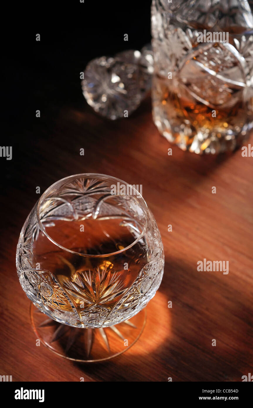 crystal brandy glass on the oak table with bottle Stock Photo - Alamy