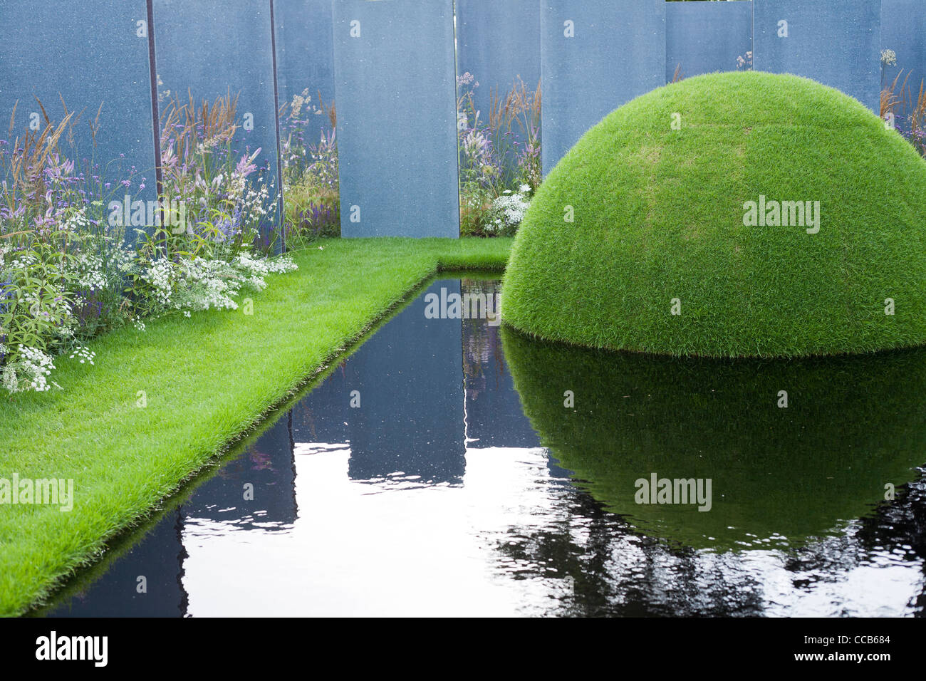 Grass ball in square pond Stock Photo - Alamy