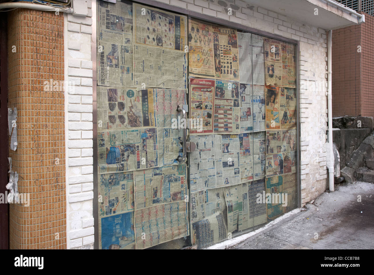 closed small shop with windows covered in newspaper hong kong hksar ...