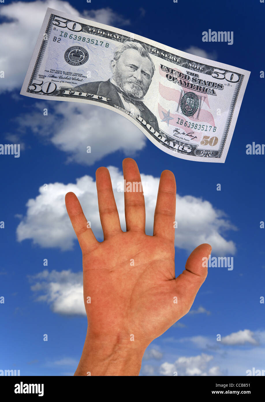 Hand reaching for a floating fifty dollar note with sky background ...