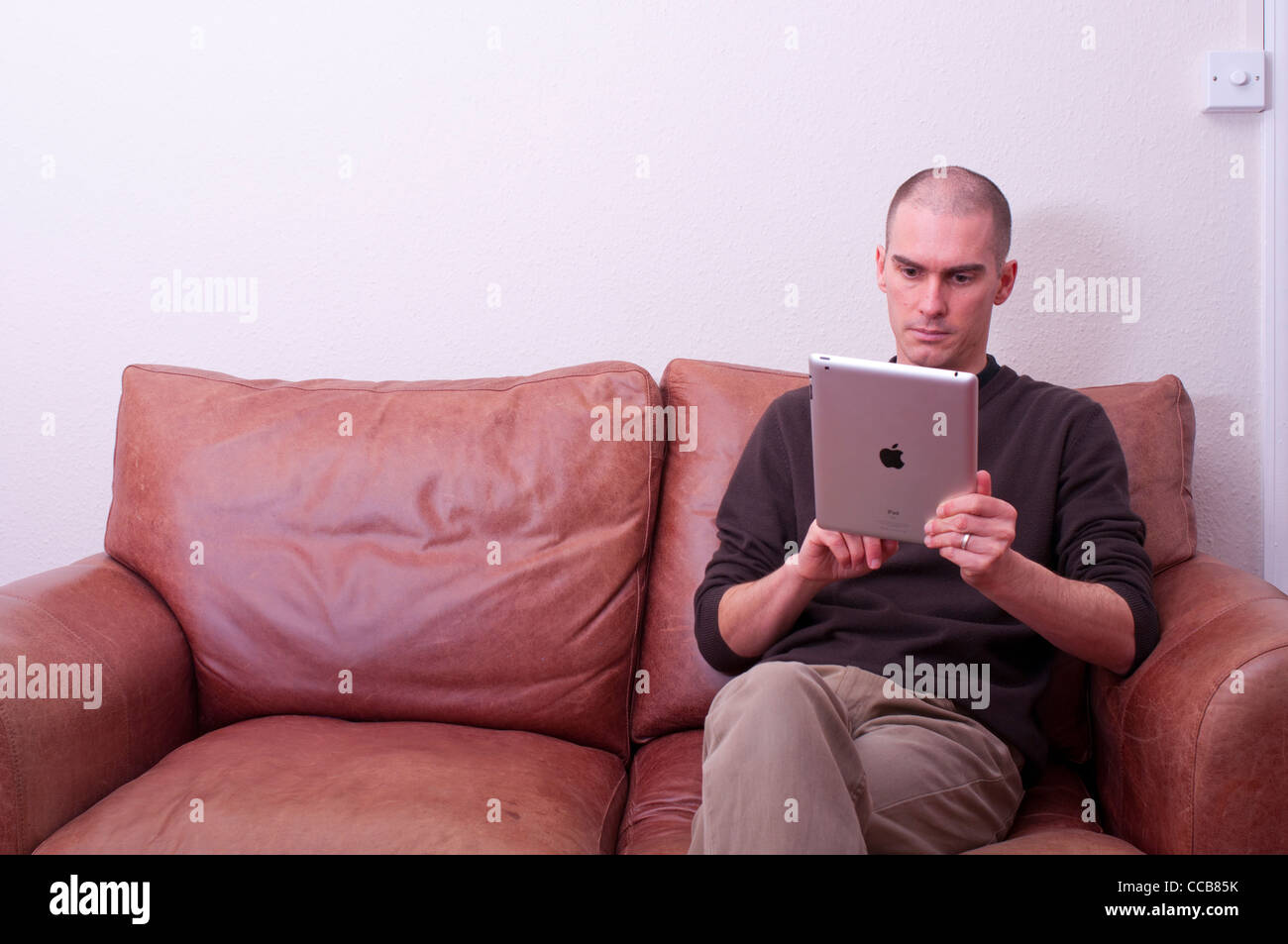 forty year old man using ipad tablet in casual setting Stock Photo - Alamy