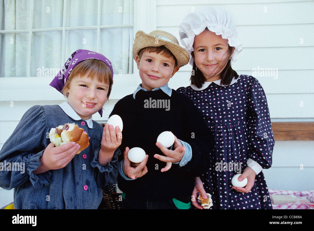 Three Farm Children having their Lunch of eggs and sandwich ;smiling ...