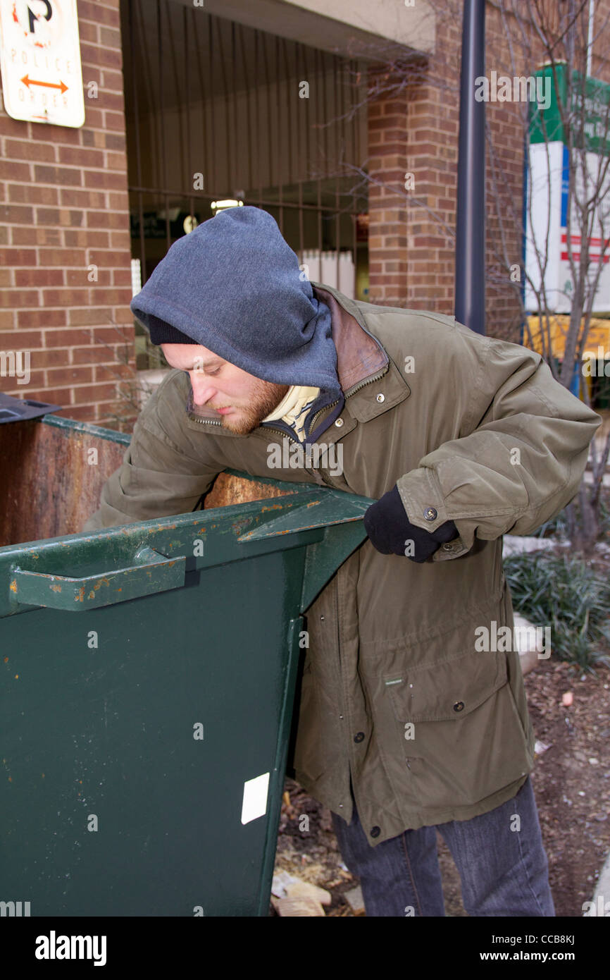 Homeless man looking into garbage dumpster Stock Photo - Alamy