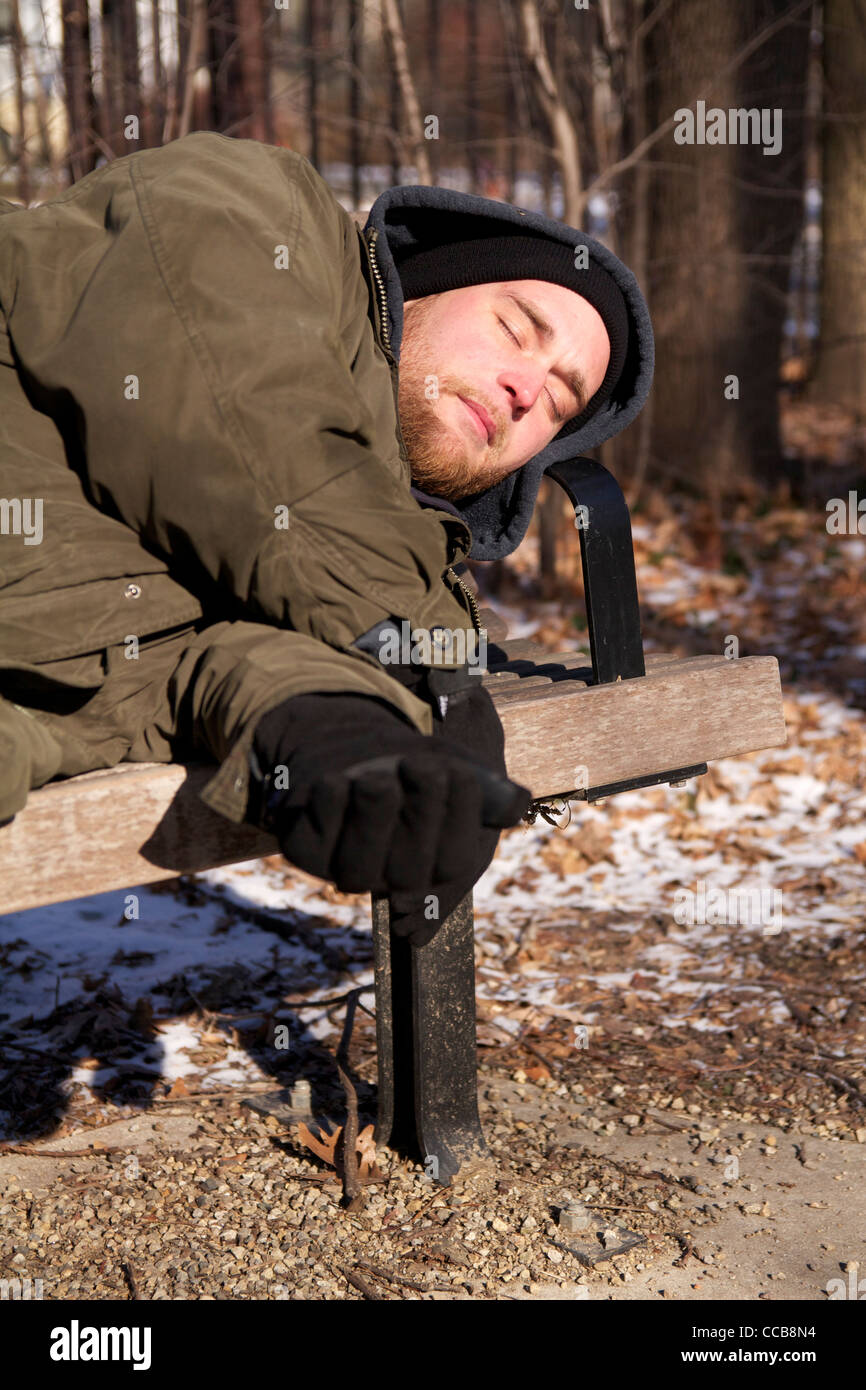Homeless man sleeping on park bench on cold winter day Stock Photo - Alamy
