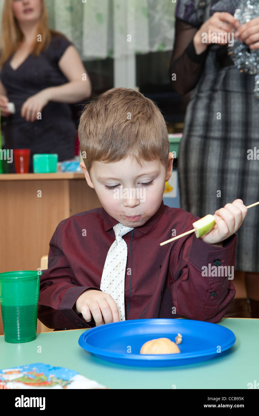 Children in Russian kindergarten sitting at the dinner table and eating ...