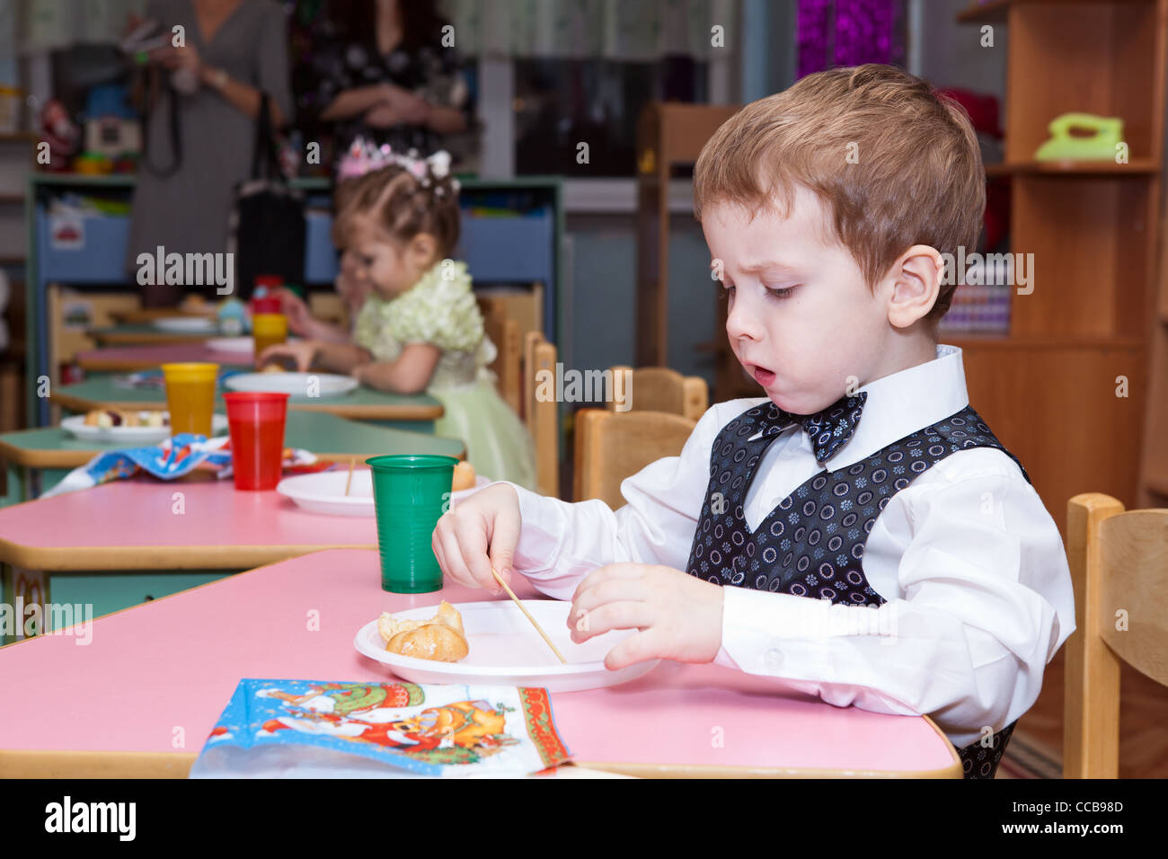 Children in Russian kindergarten sitting at the dinner table and eating ...