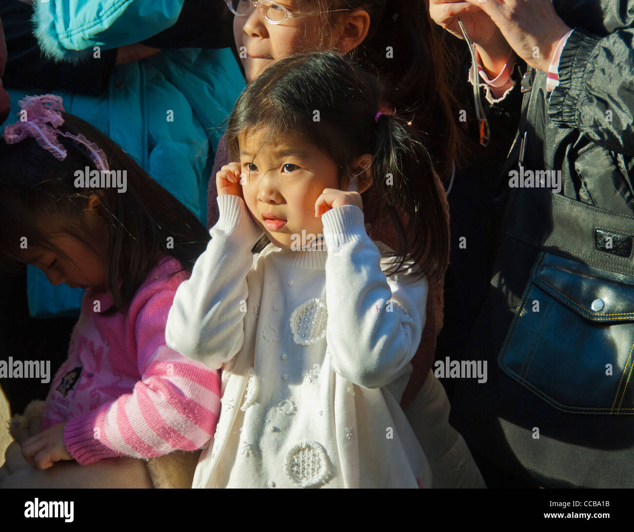 Asian female child holding ears noise hi-res stock photography and ...