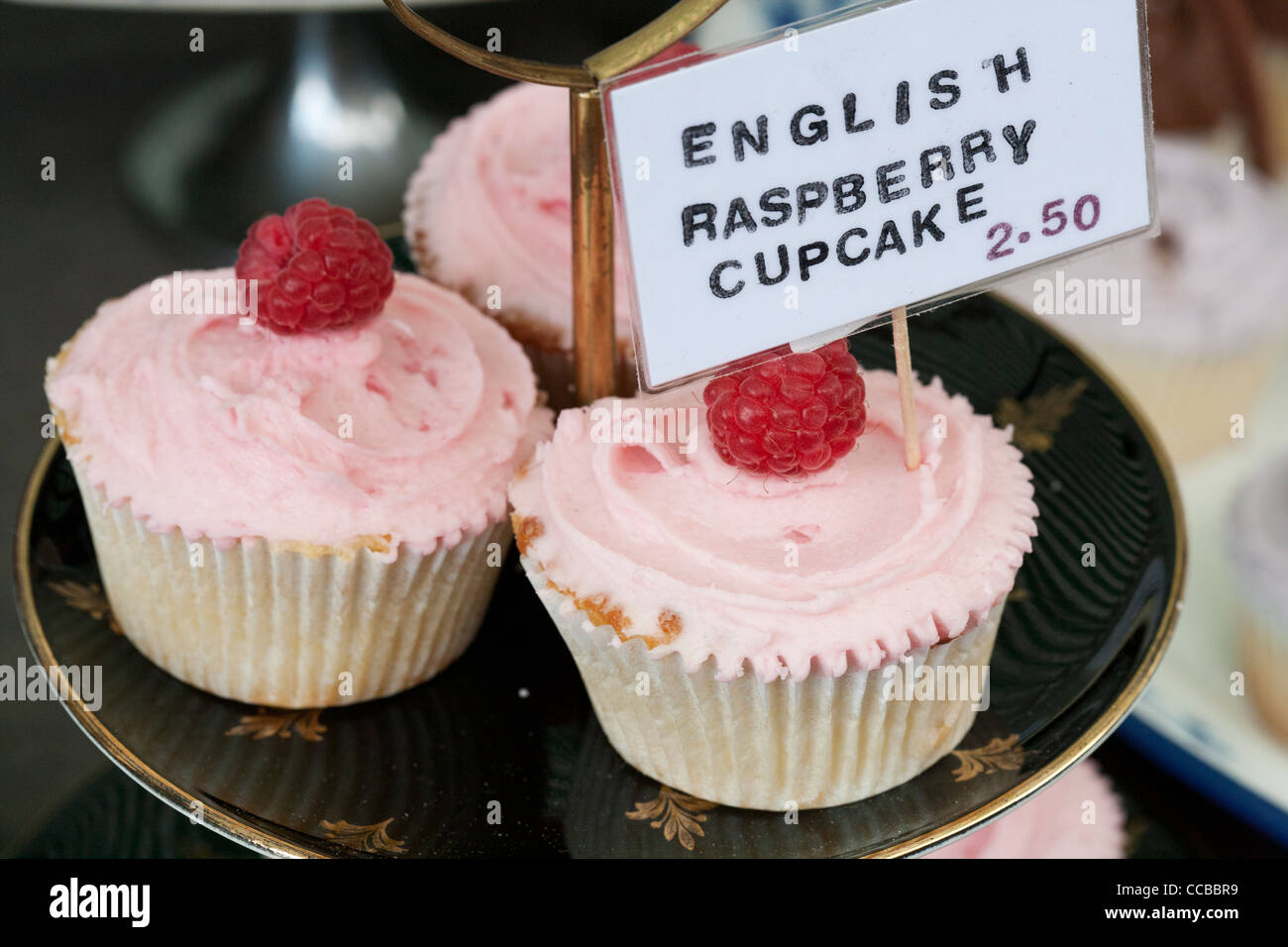 three English raspberry cup cakes on a plate Stock Photo - Alamy