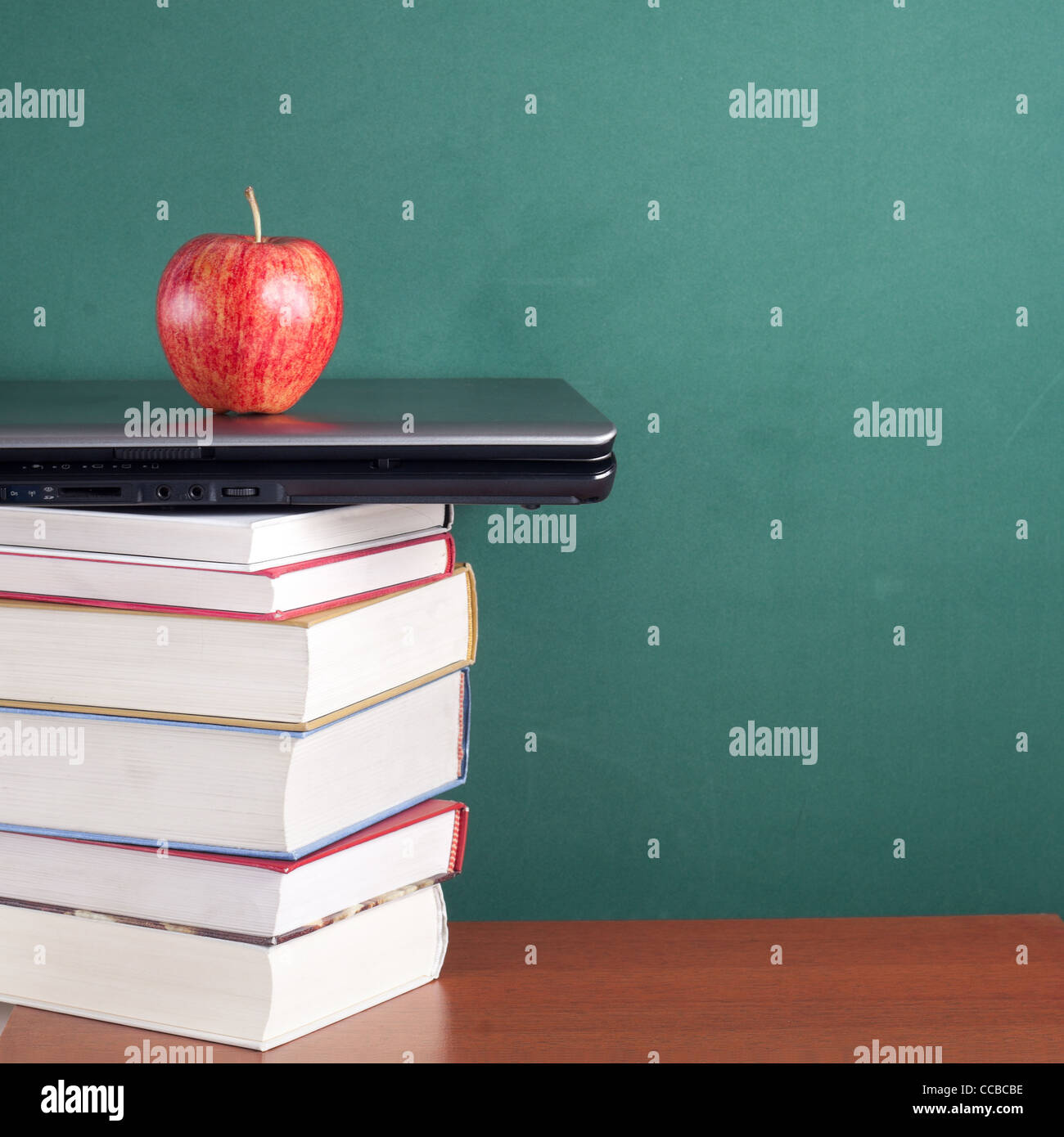 Notebook and apple over books Stock Photo - Alamy