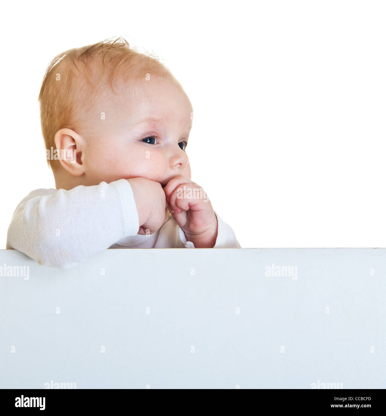 Infant baby behind whiteboard with lot of copyspace for advertisement ...