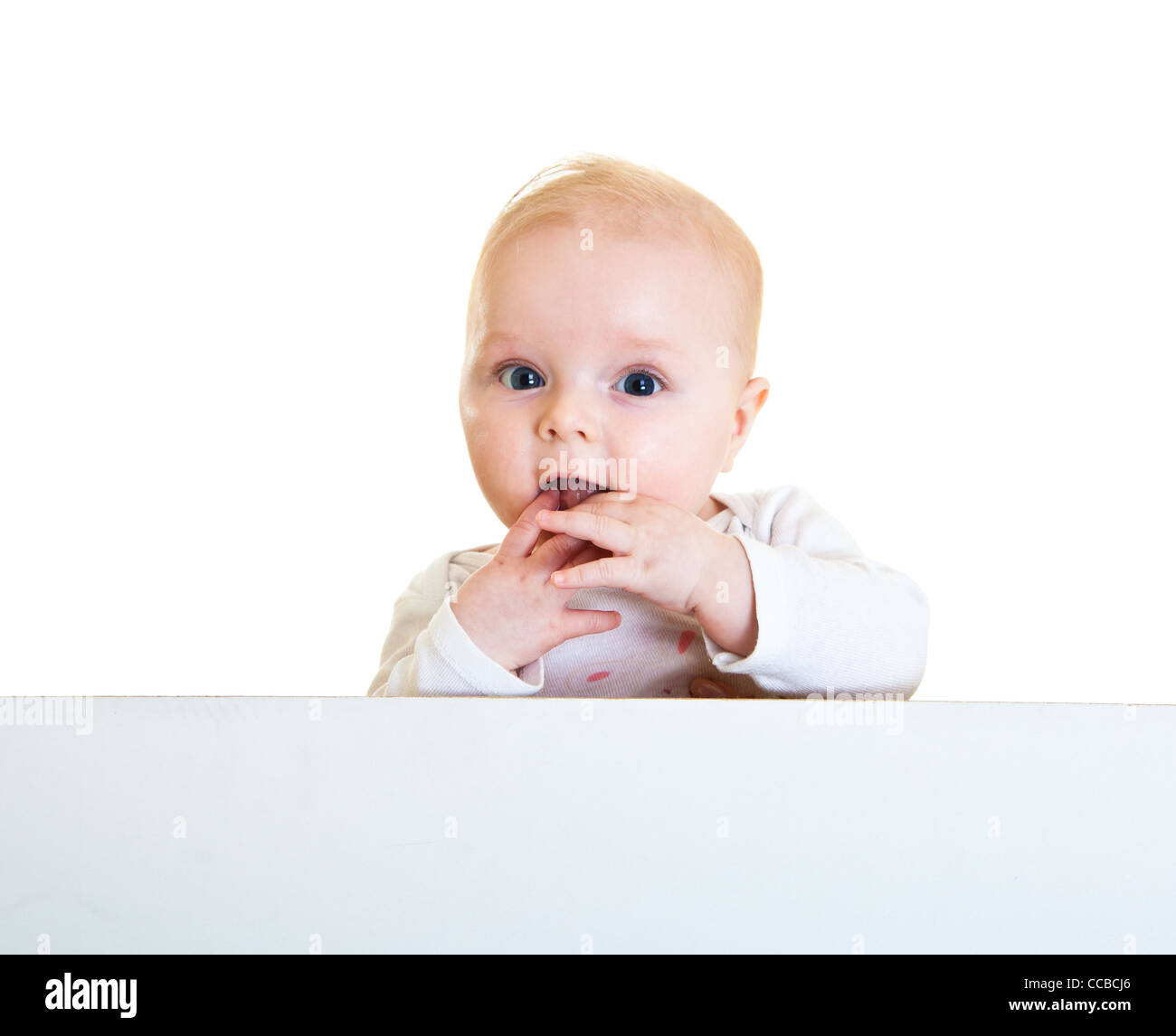 Infant baby behind whiteboard with lot of copyspace for advertisement ...