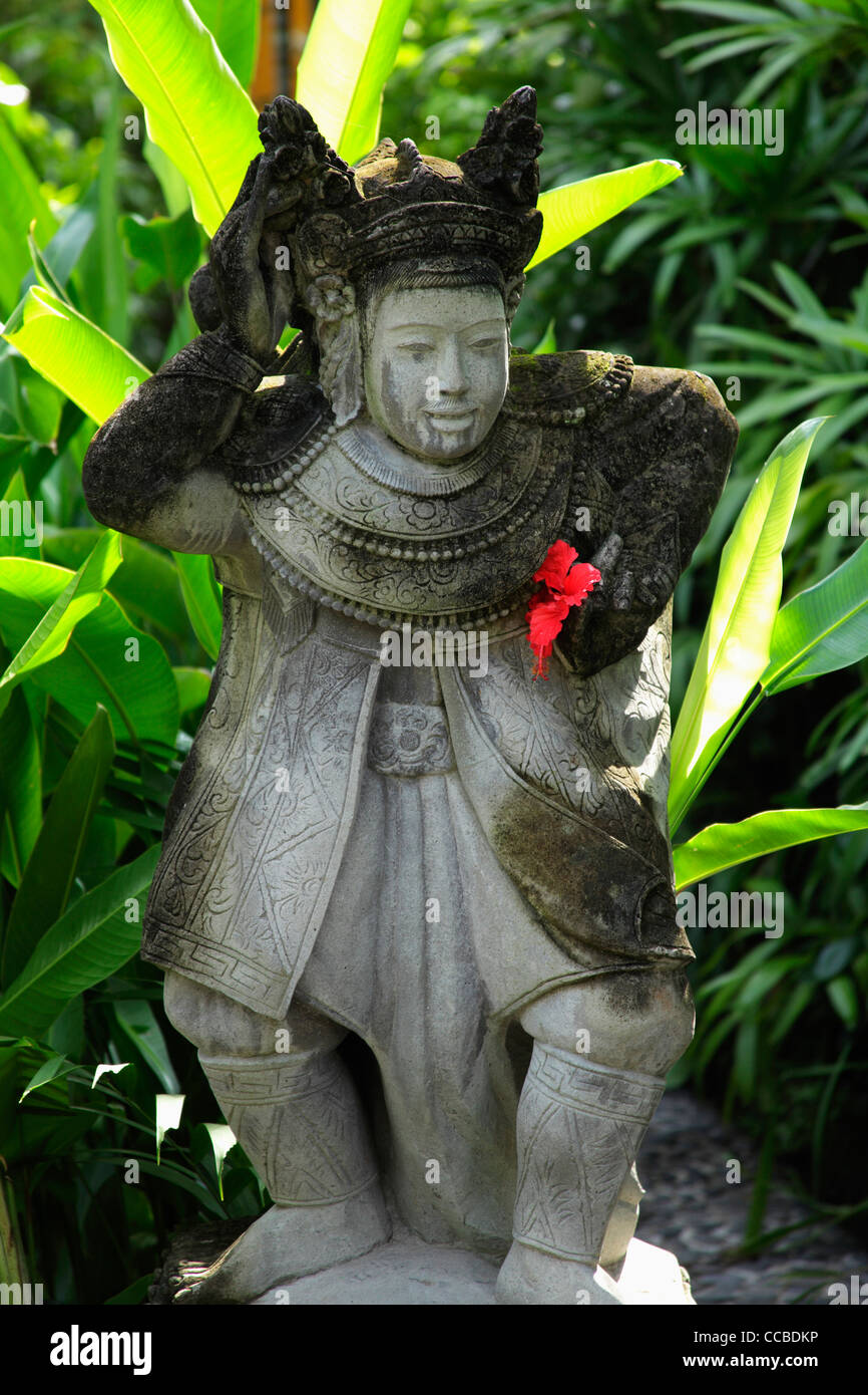 stone Hindu statue with red flower Stock Photo - Alamy